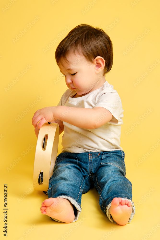 Toddler baby plays the tambourine, a child with a percussion musical ...
