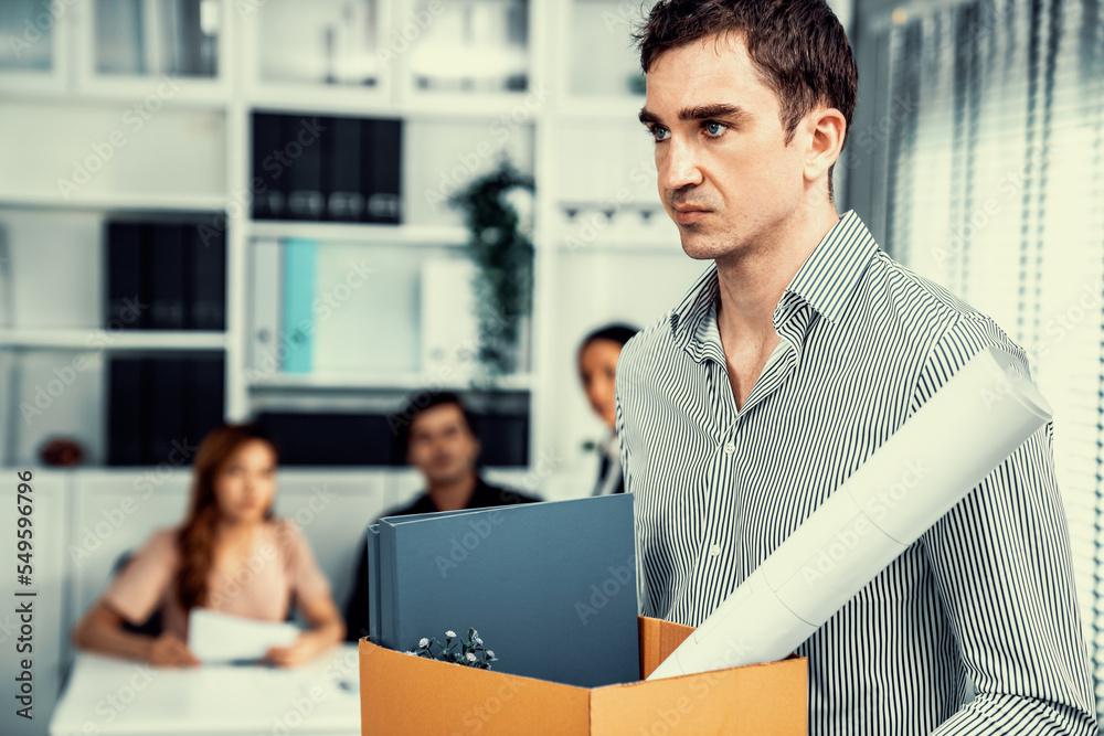Depressed and disappointed employee packing his belongings after being ...
