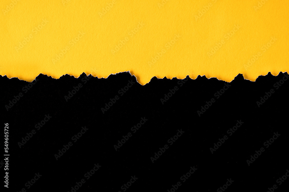 Torn half sheet black paper horizontal on yellow paper at the bottom ...