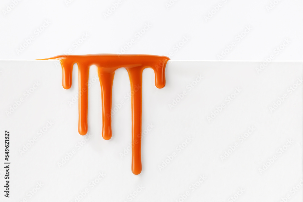 Dripping caramel drops of sweet caramel sauce isolated on white ...
