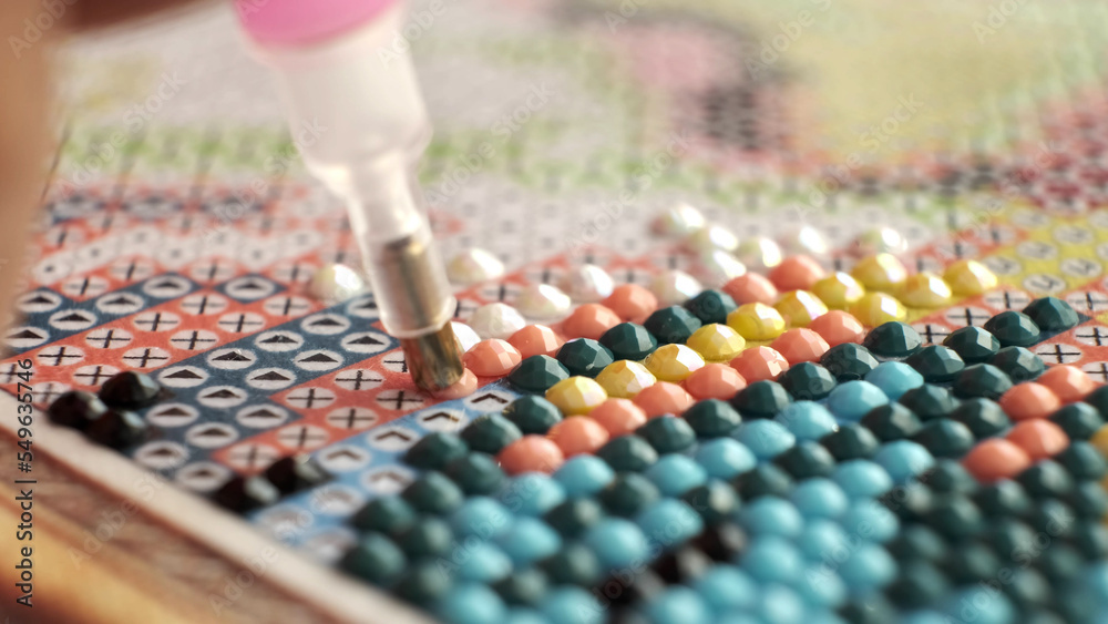 Diamond painting with pen closeup. art therapy concept. Laying out a ...