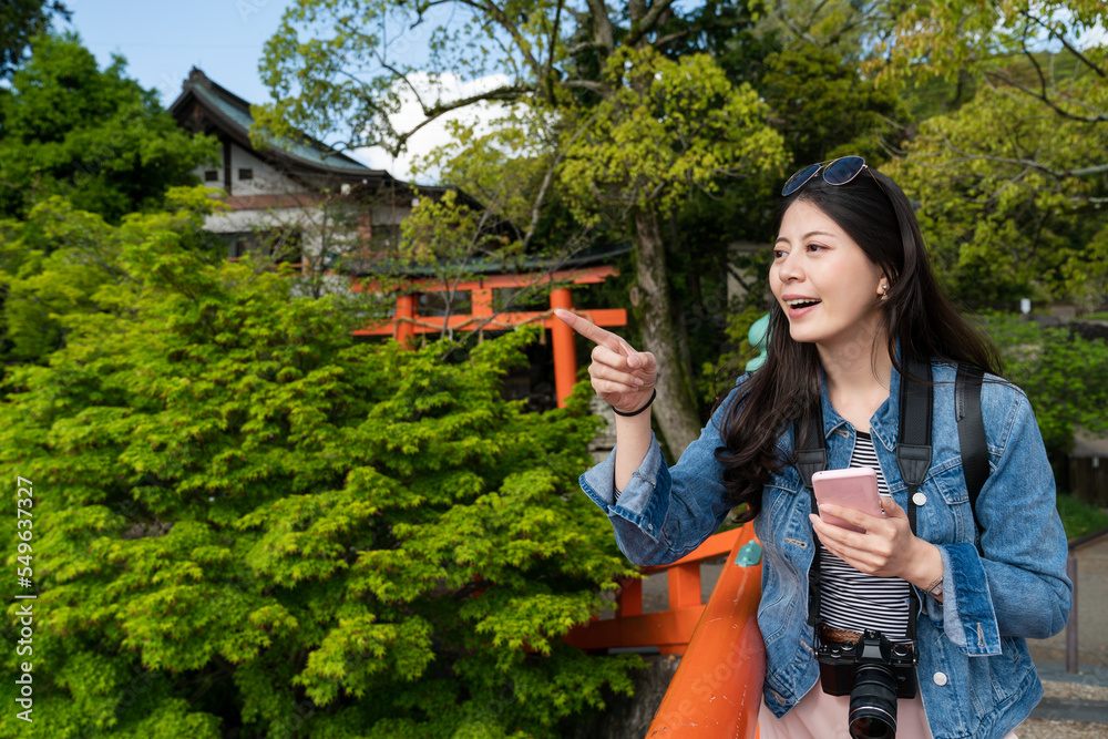asian Japanese woman tourist finger pointing at landmark at distance ...