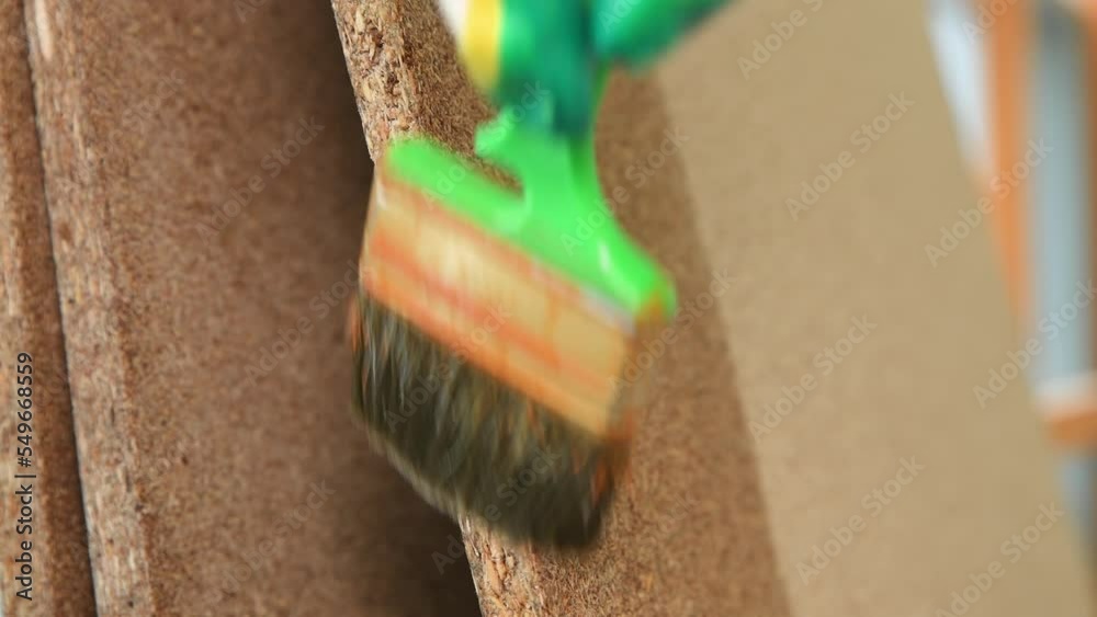 Impregnation of chipboard with a primer using a brush. Painted panel ...