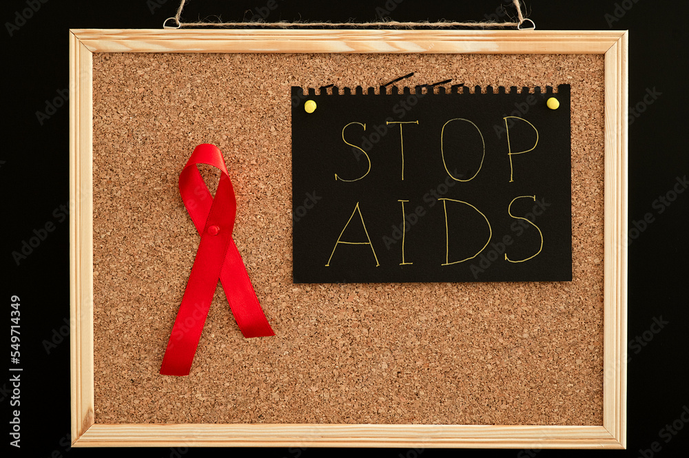 World AIDS Day. Red ribbon and STOP AIDS note as a symbol of struggle ...