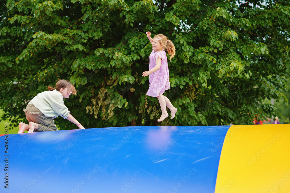 Little preschool girl jumping on trampoline. Happy funny toddler child ...