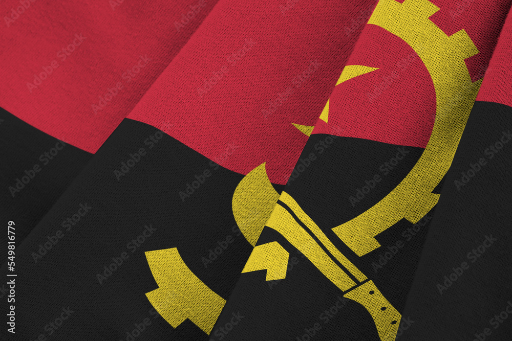 Angola flag with big folds waving close up under the studio light ...