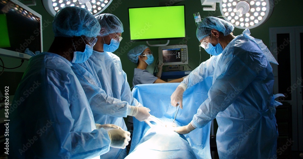 Portrait of professional surgeons using medical instruments in ...