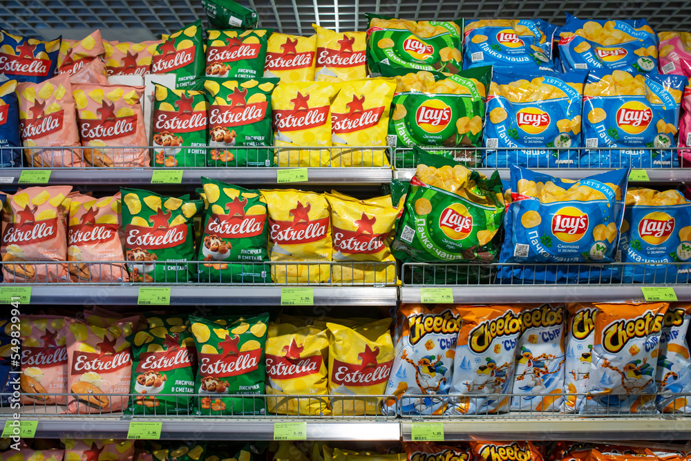 Various brands of potato chips Lay's, Estrella, and Cheetos on shelf in ...