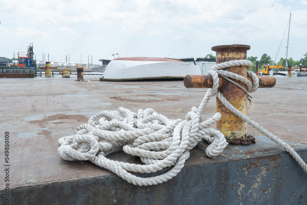 heavy cotton nautical rope, still wet and salty from recent use, tying ...