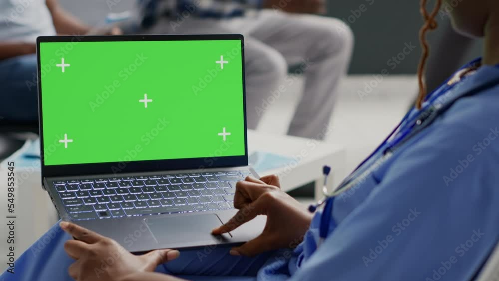 Medical assistant looking at wireless pc with greenscreen, analyzing ...