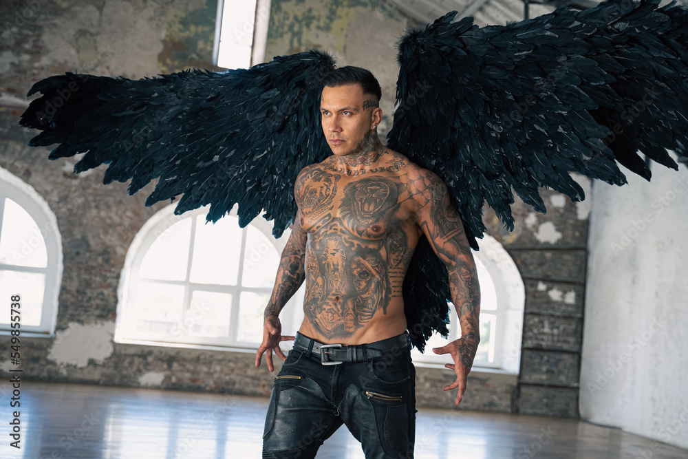 angel man with black wings, stand posing at camera. man fall from ...