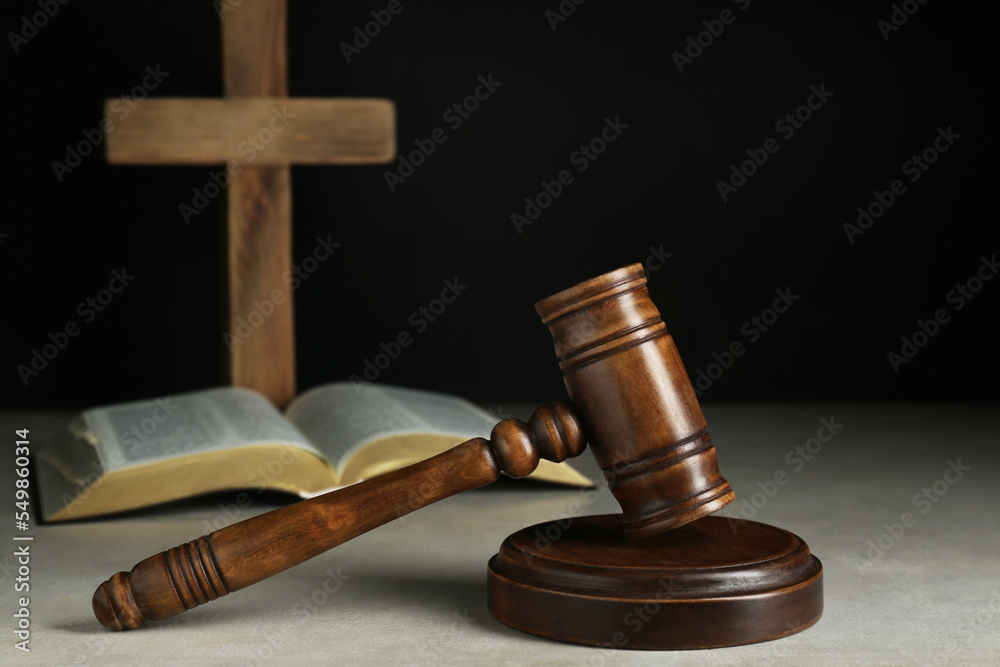 Judge gavel, bible and wooden cross on light grey table against black ...