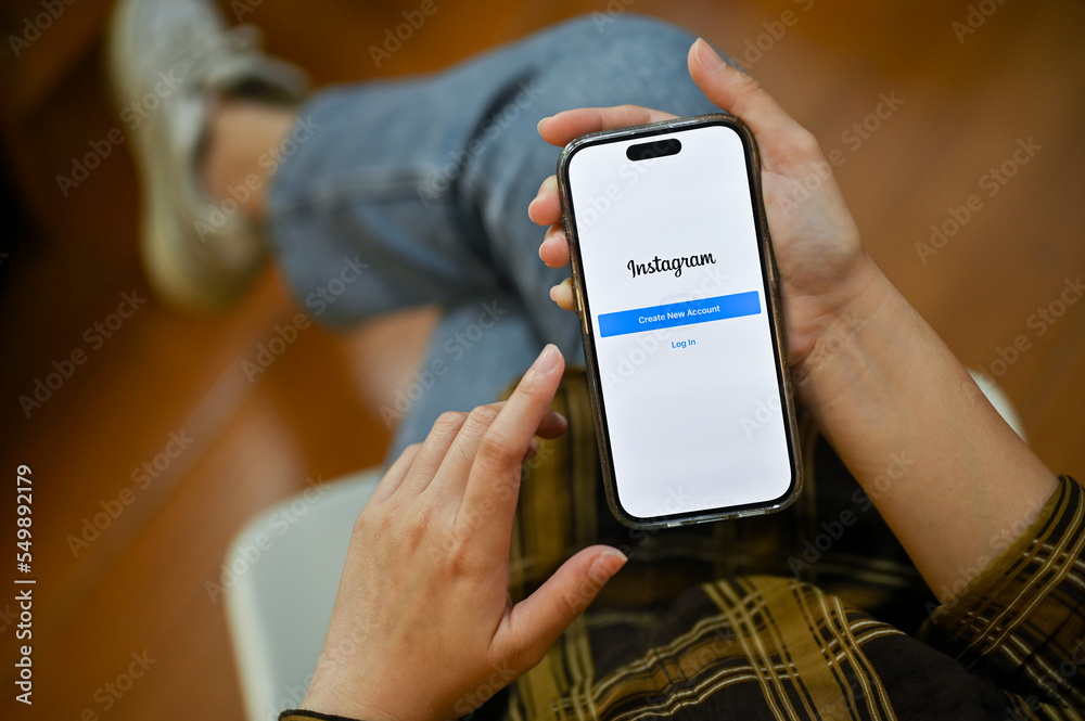 Female using her smartphone, holding a smartphone with Instagram logo ...