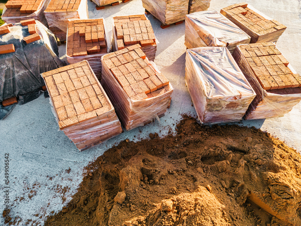Foto de Pallets with red ceramic bricks on the roof of a building under ...