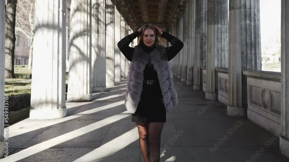 Blond Girl Walking Through Terrace Corridor Colonnade Looking At Camera ...