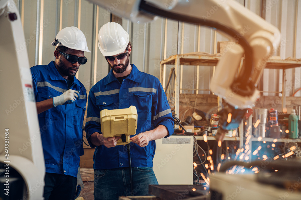 Foto de Team of Engineers is controlling robot arm machine welding ...