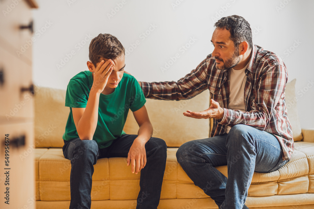 Father and son are talking at home. Son is having issues and father is ...
