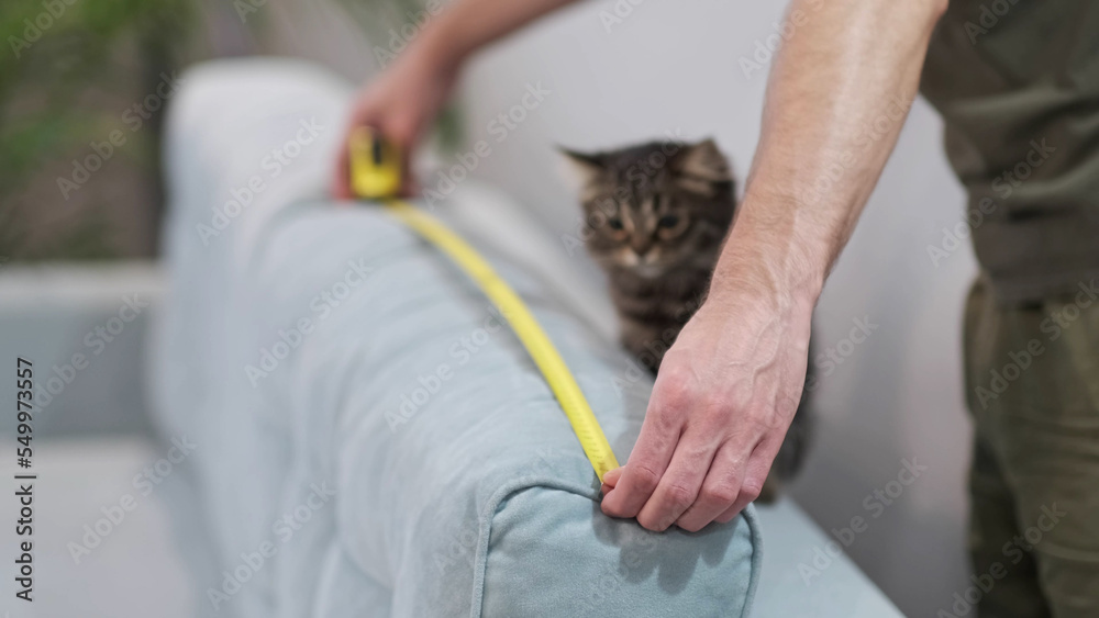 Fotka „person uses a building meter to measure a sofa, moving house ...