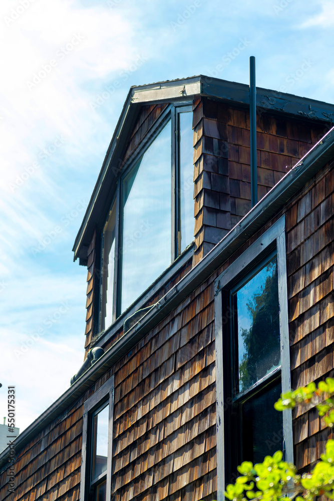 Horizontally slatted timber and wooden framed house with dark window ...