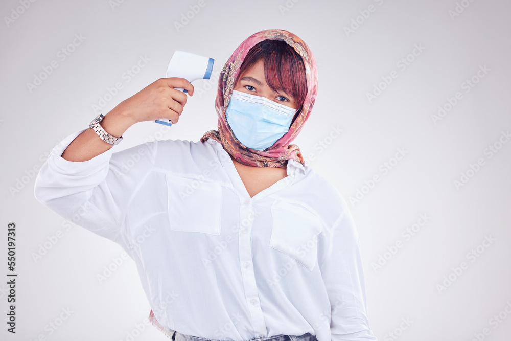Muslim woman, covid face mask and thermometer gun on white studio ...