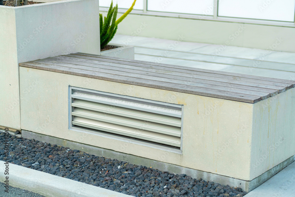 Decorative modern bench with beige stucco exterior and slatted polished ...