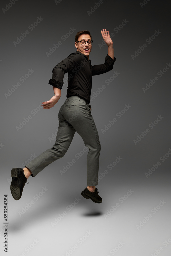 Running away. Happy young man, student, business in black classic style ...