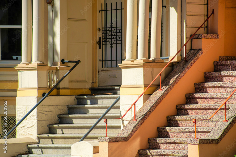 Row of stairs with visible metal hand rails with white red exterior of ...