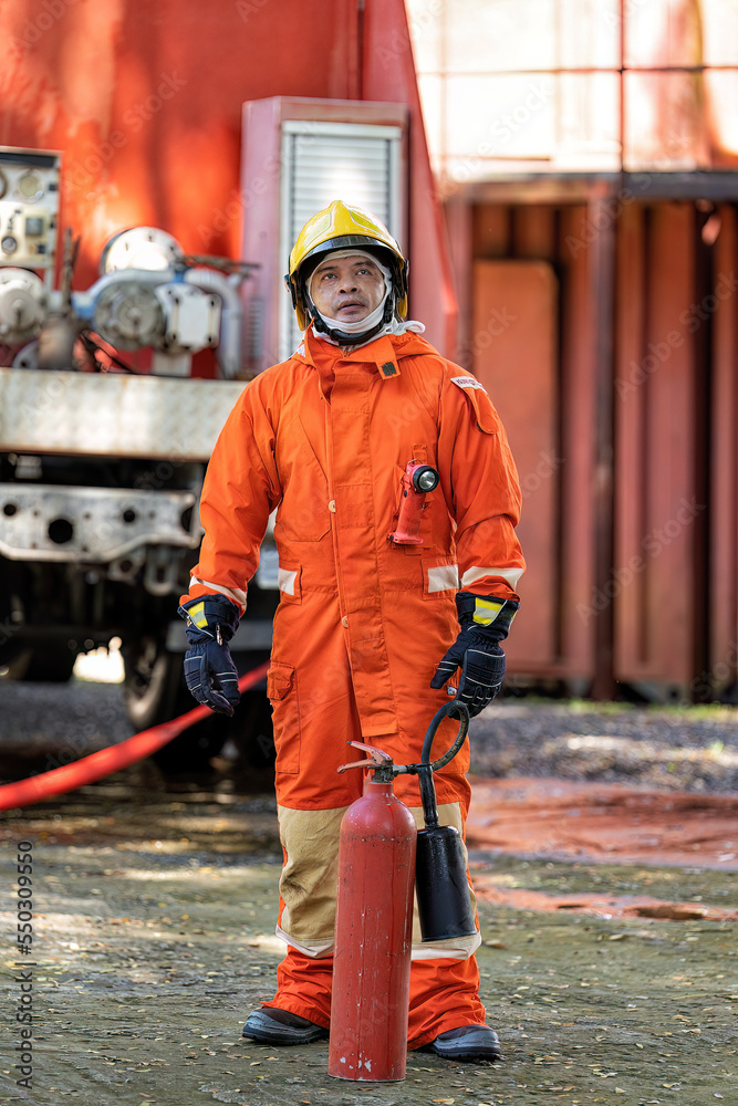 Fireman wearing fire protection suite and oxygen tank exercise hold axe ...