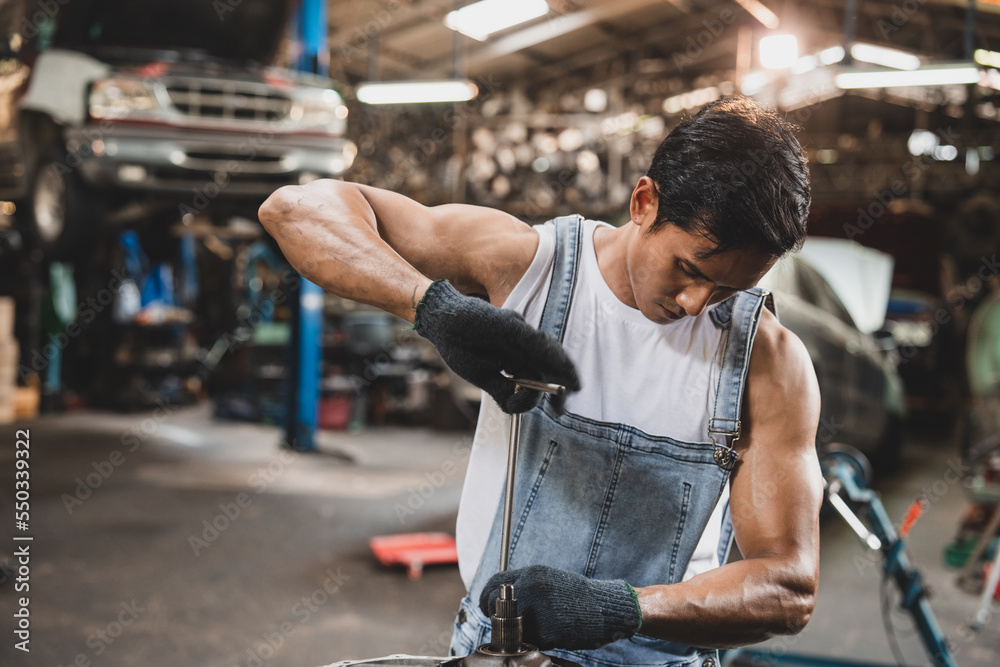 Handsome young male mechanic and car repair service man using various ...