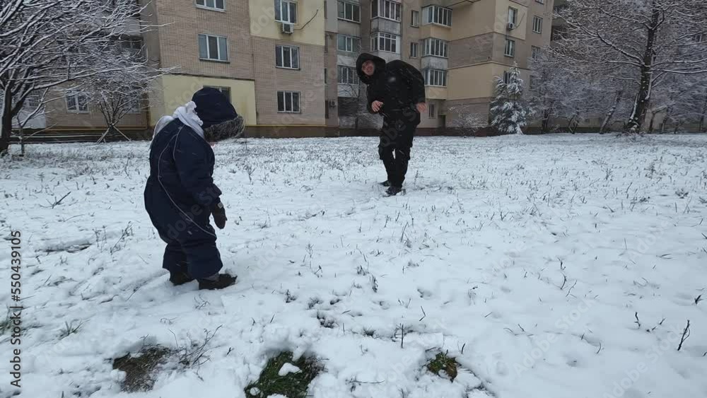 Father and son play snowballs. A little boy is enjoying the winter ...