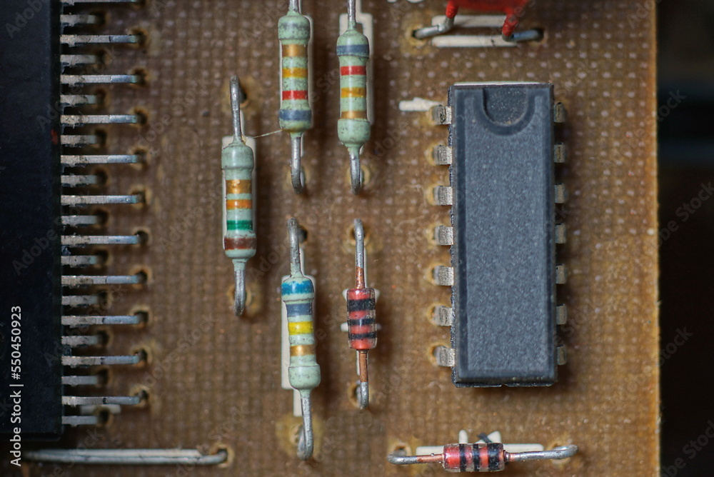 part of an old brown electronic circuit with a black transistor and ...