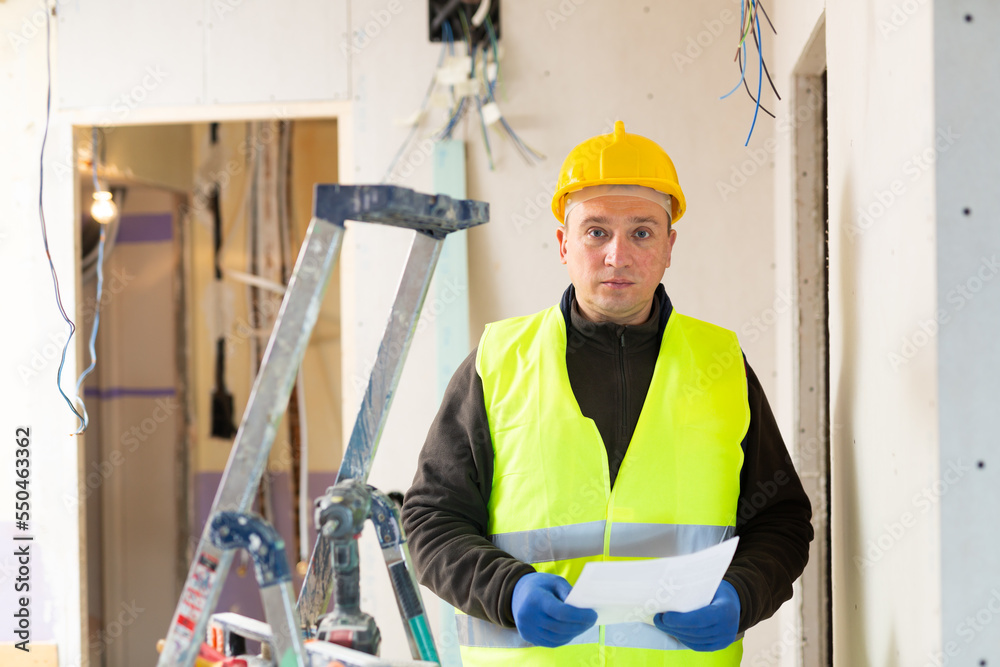 Professional male contractor looking at room and determining scope of ...