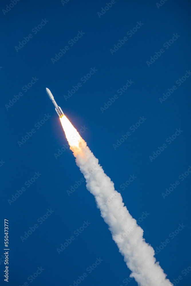 A rocket blasting off and soaring into space in the sky going upward ...