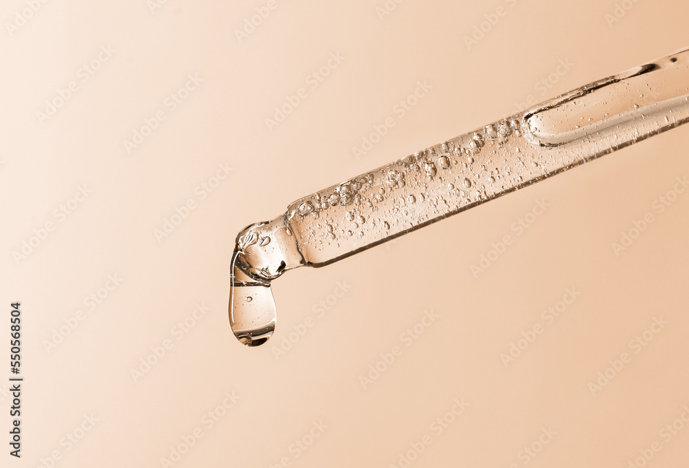 serum pipette close-up with falling drop on a beige background Stock 写真 ...