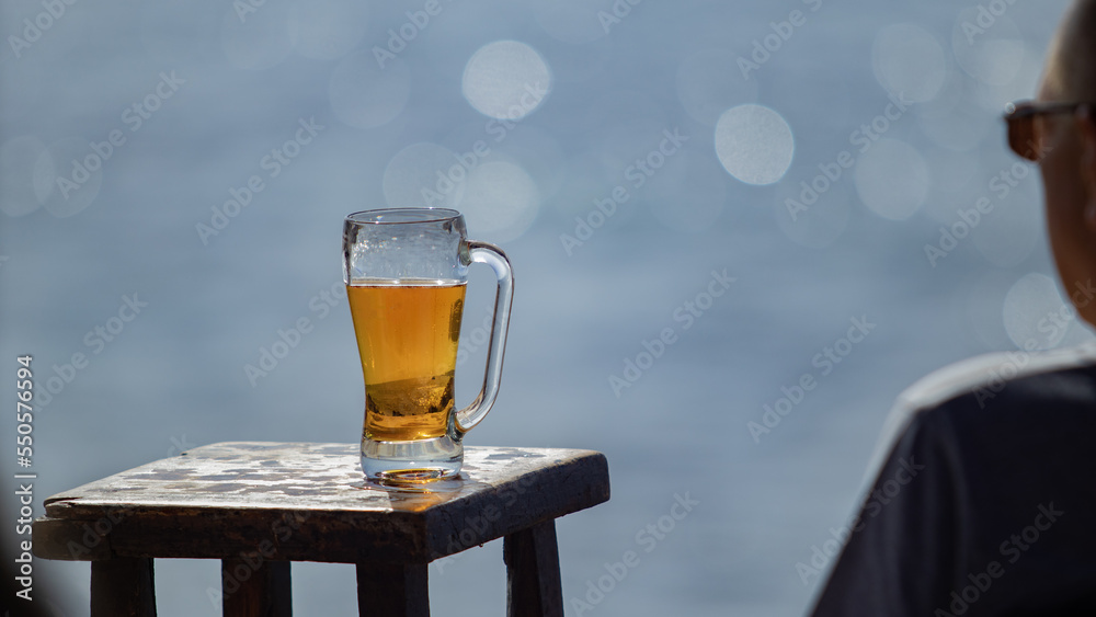 Gorgeous photo of a man drinking an ice-cold beer by the sea on a ...