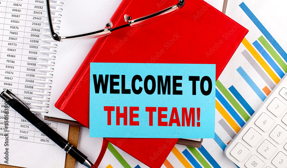WELCOME TO THE TEAM text on sticky on red notebook on chart background ...