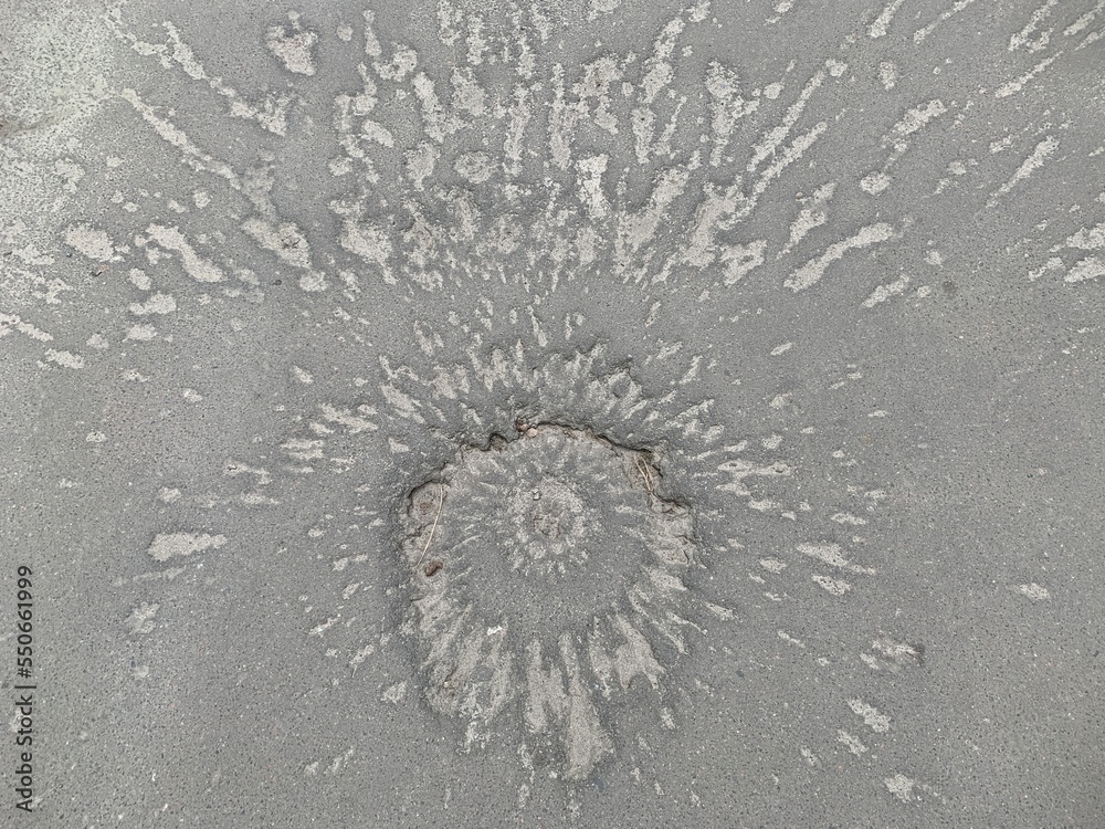 Funnel on the pavement from the explosion of a shell. Traces of the war ...