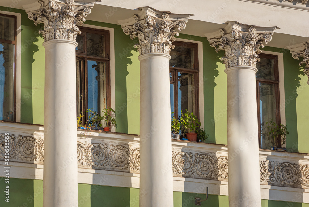 Tomatoes grow in plastic containers in windows between massive columns ...