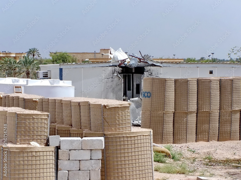 Bombed out trailer surrounded by blast barriers at a British Forward ...