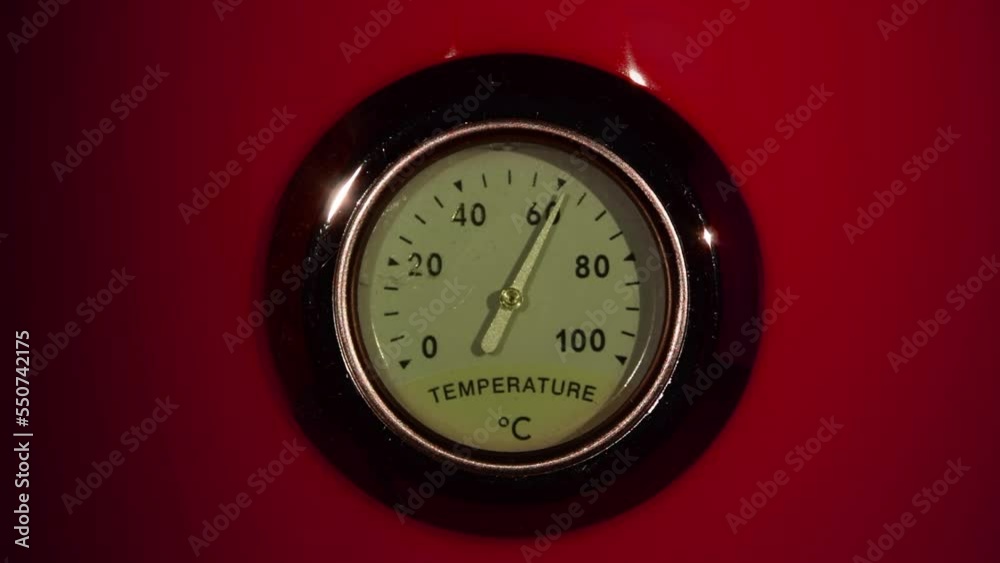 Moving instrument pointer on front side of red vintage temperature ...