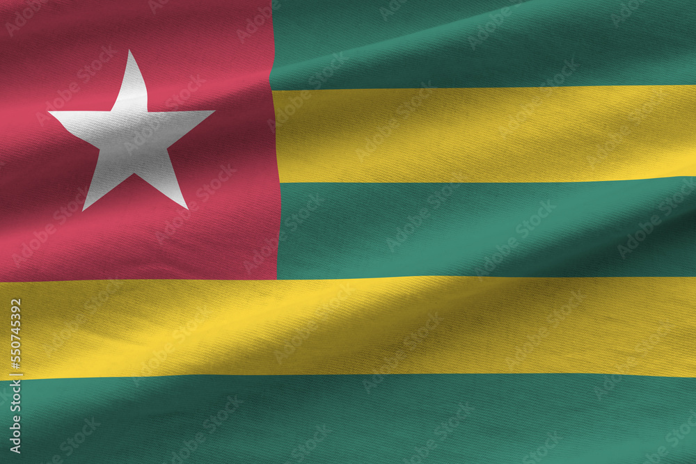 Togo flag with big folds waving close up under the studio light indoors ...