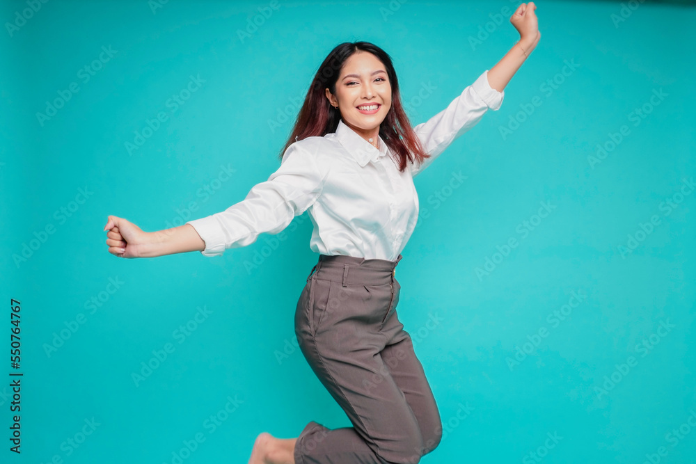 Photo of active Asian girl or employee jump raise hands up wear white ...