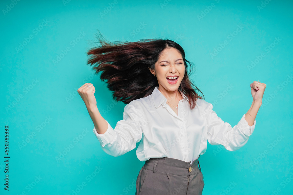 A young Asian woman with a happy successful expression wearing white ...