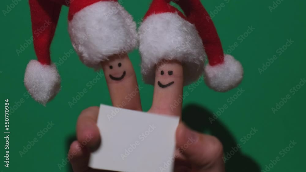 Fingers dressed in Santa-Claus red-white hats. Two happy finger smileys ...