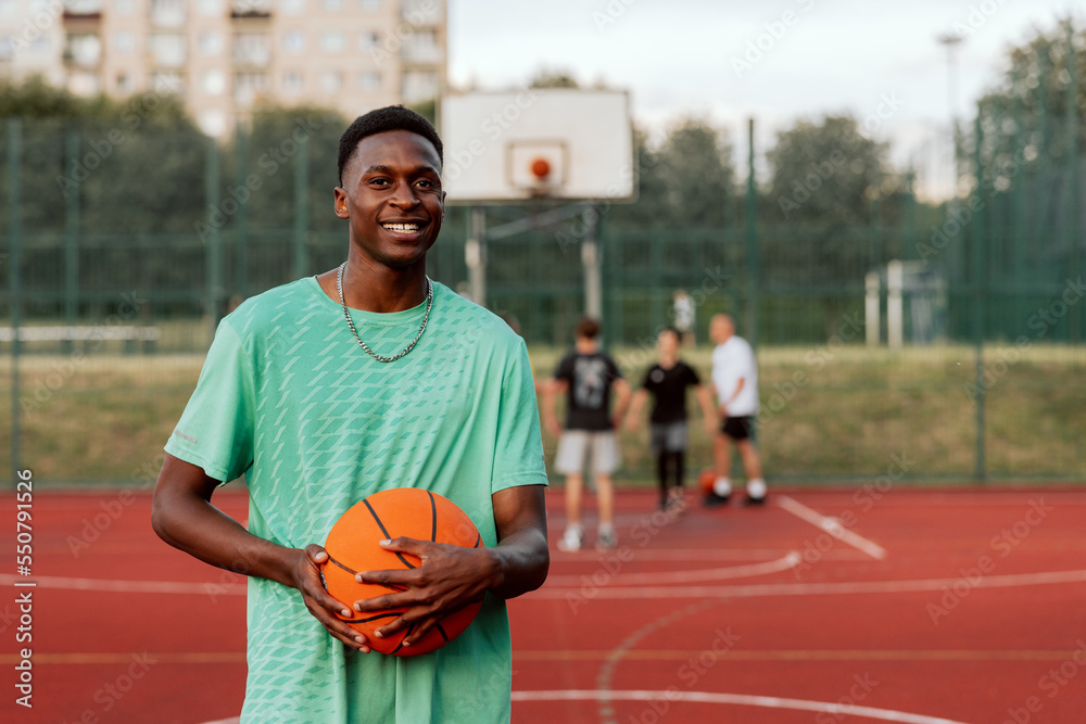 Portrait of delighted african american basketball player guy standing ...