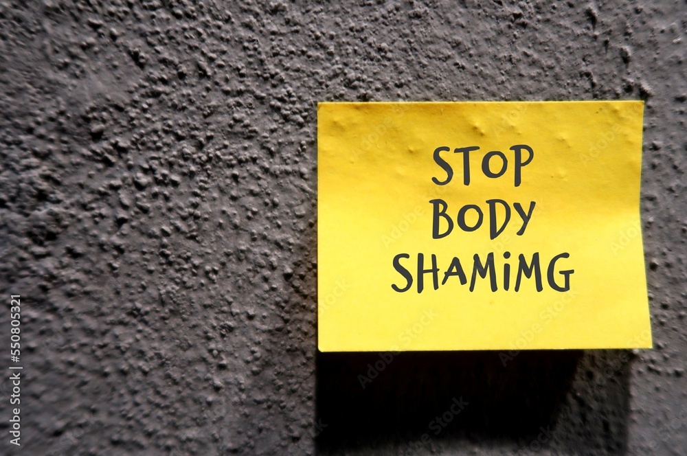 Grey cement concrete rough texture wall background with text STOP BODY ...