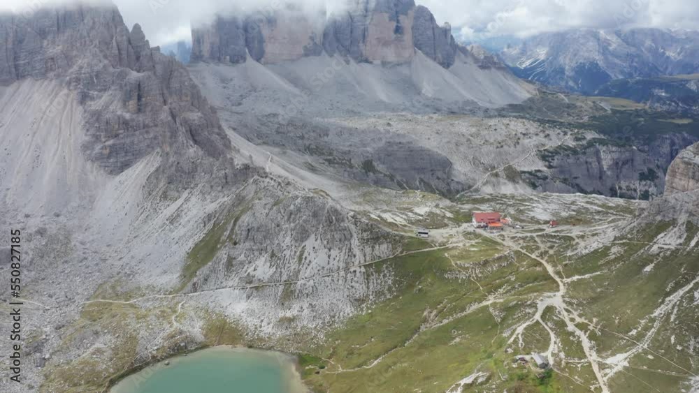 Drone tilt up over alpine lakes and Rifugio Locatelli (Dreizinnenhütte ...