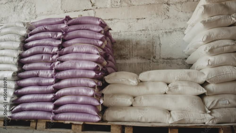 Warehouse space for storing stacks of white and purple sacks of flour ...