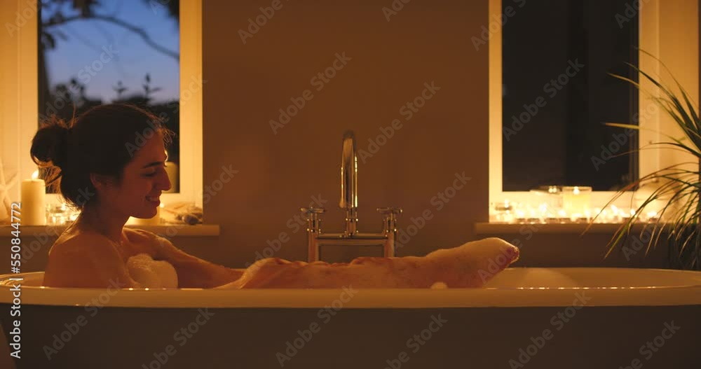 Woman, relax and cleaning body in bath, candles and zen with beauty ...