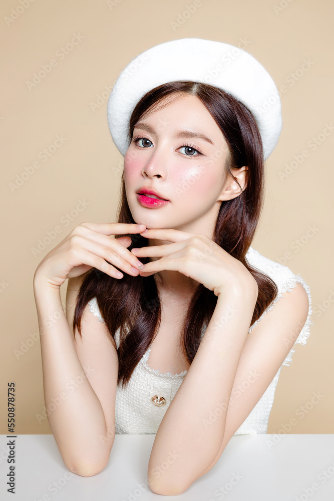 Cute Asian woman with perfect clear fresh skin. Pretty girl model wearing white beret and ...